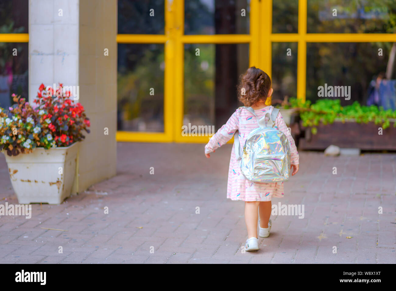 Curly cute little toddler girl back to school with holographic ...