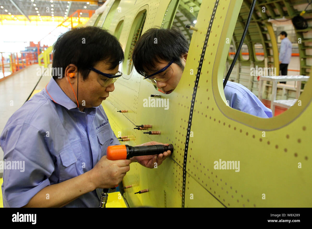 Chinese technicians rivet sections of the fuselage to assemble China¯s ...