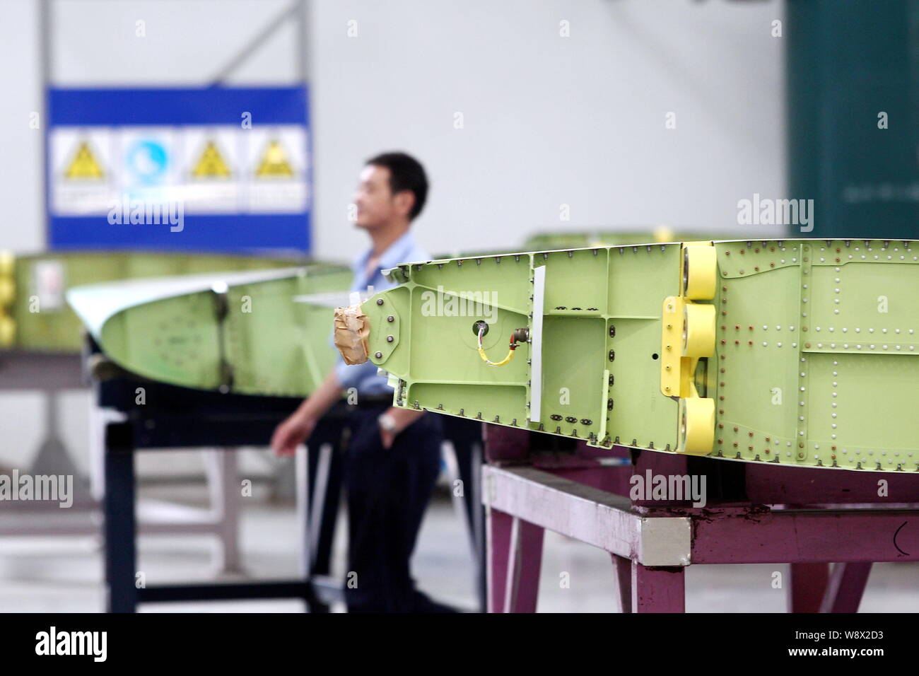 A Chinese worker walks past horizontal stabilizers for the new Boeing ...
