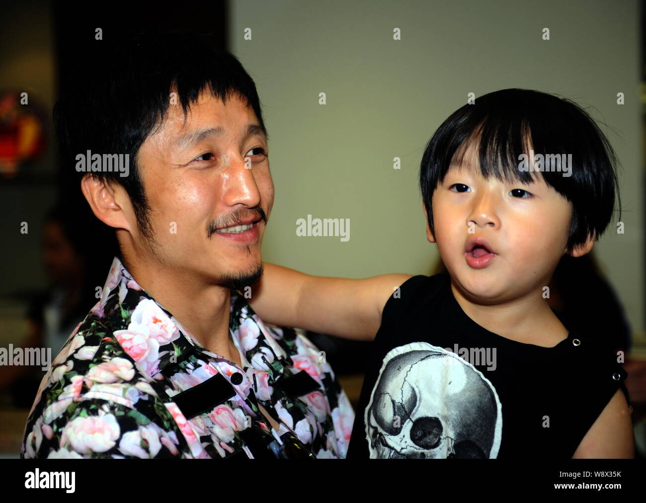 Chinese boxer Zou Shiming, left, smiles as he holds his son at an ...