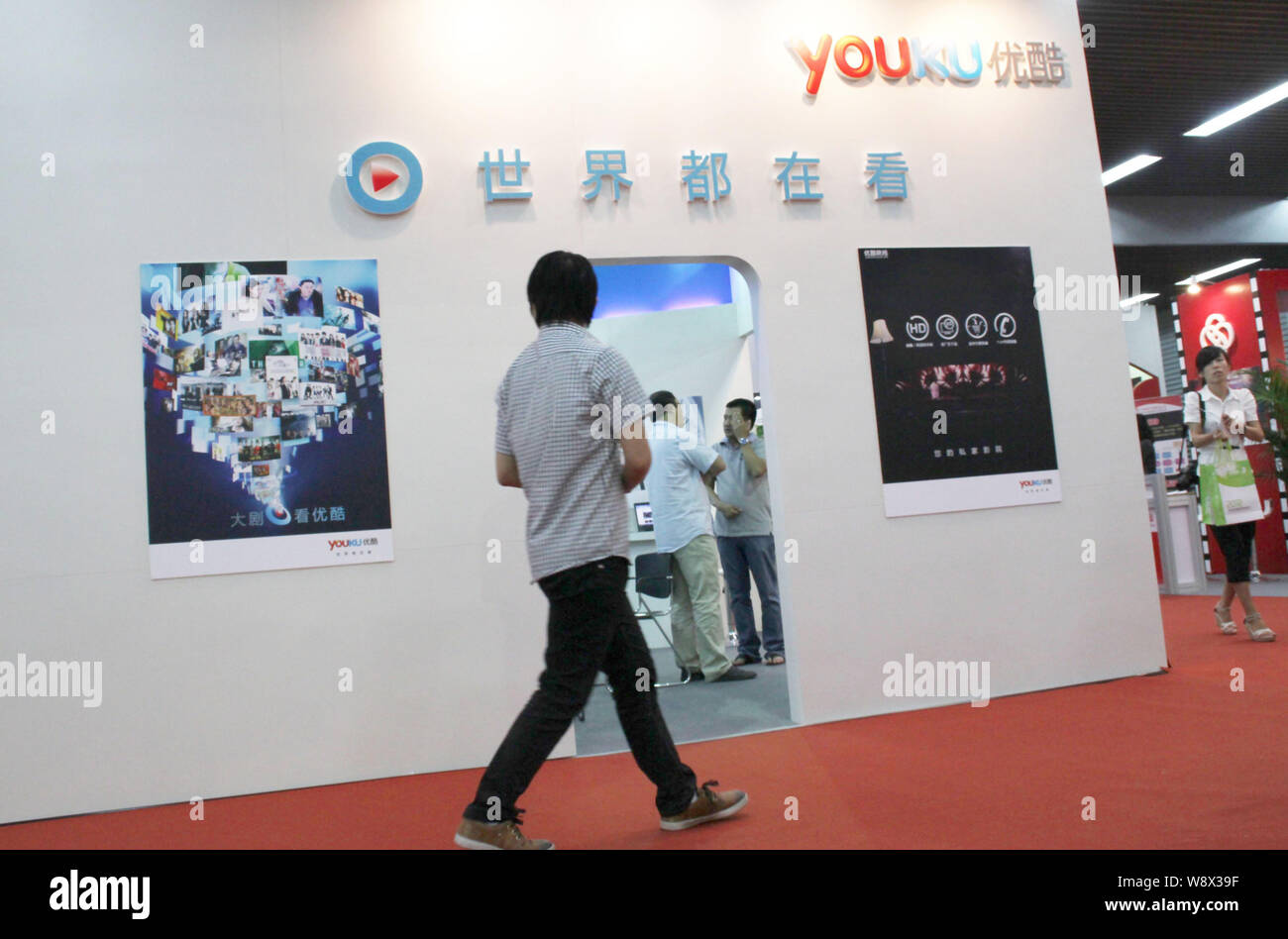 --FILE--A visitor walks past the stand of online video website youku ...