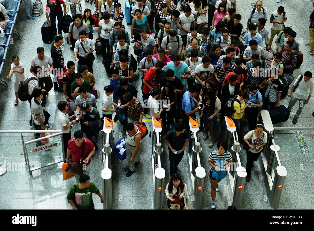 Chinese passengers queue up to check in at the Hangzhou Railway Station ...
