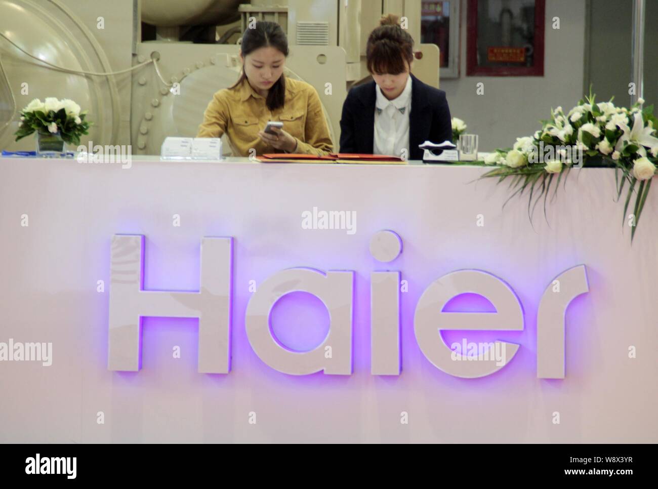 Chinese employees are seen at the stand of Haier during the 2014 ...