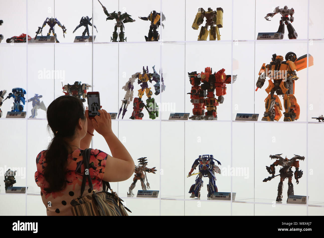 A visitor takes photos of Transformers toys during an exhibiton at the ...