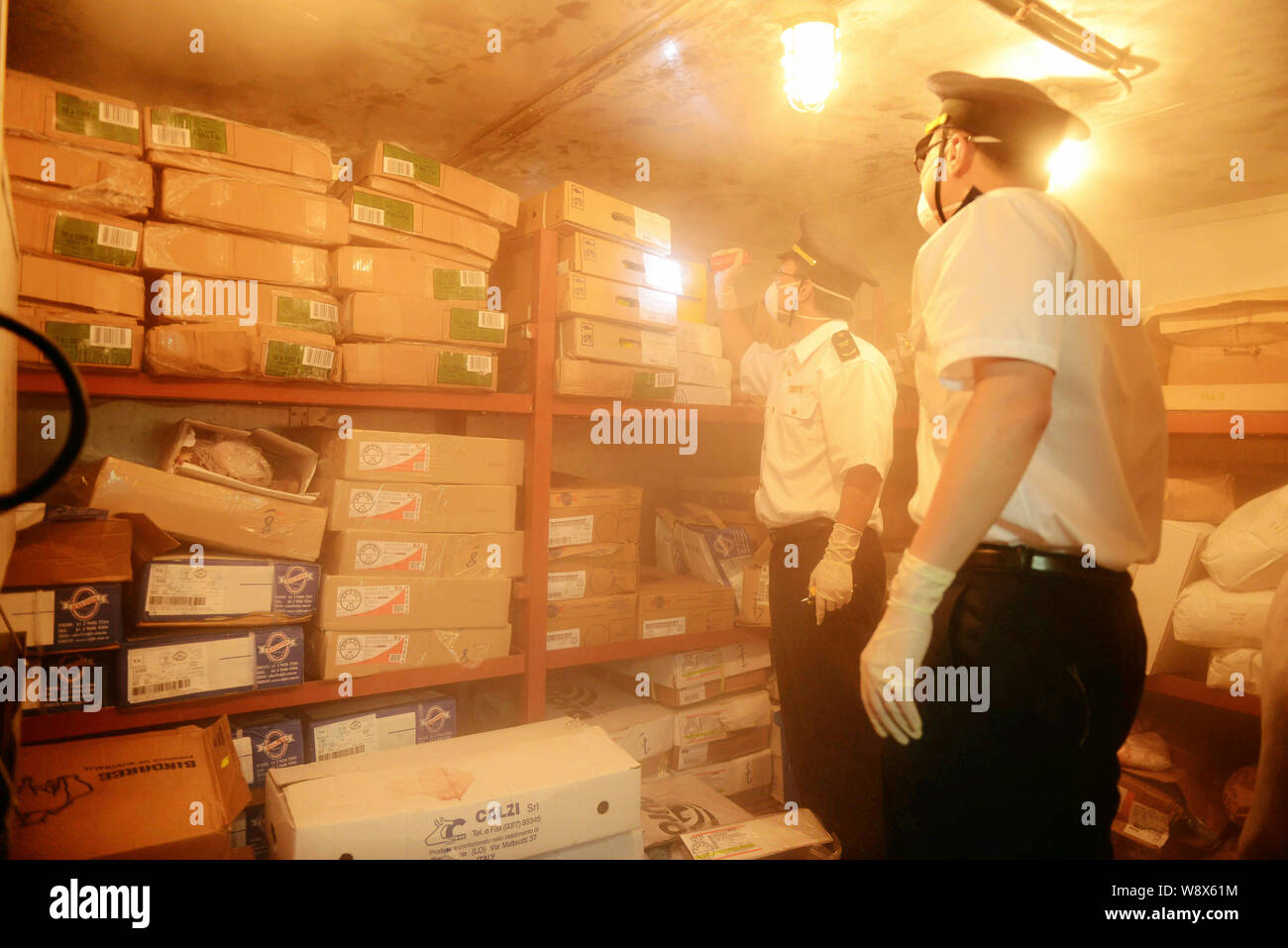 Chinese quarantine officers wearing masks examine a food cabin in the ...