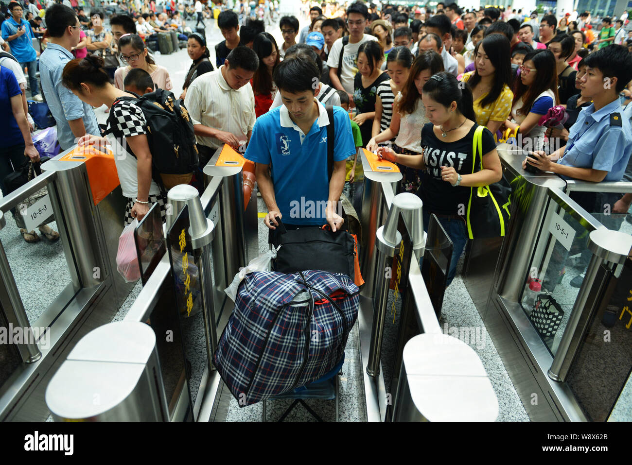 Passengers who are coming back from the Mid-Autumn Festival queue up to ...