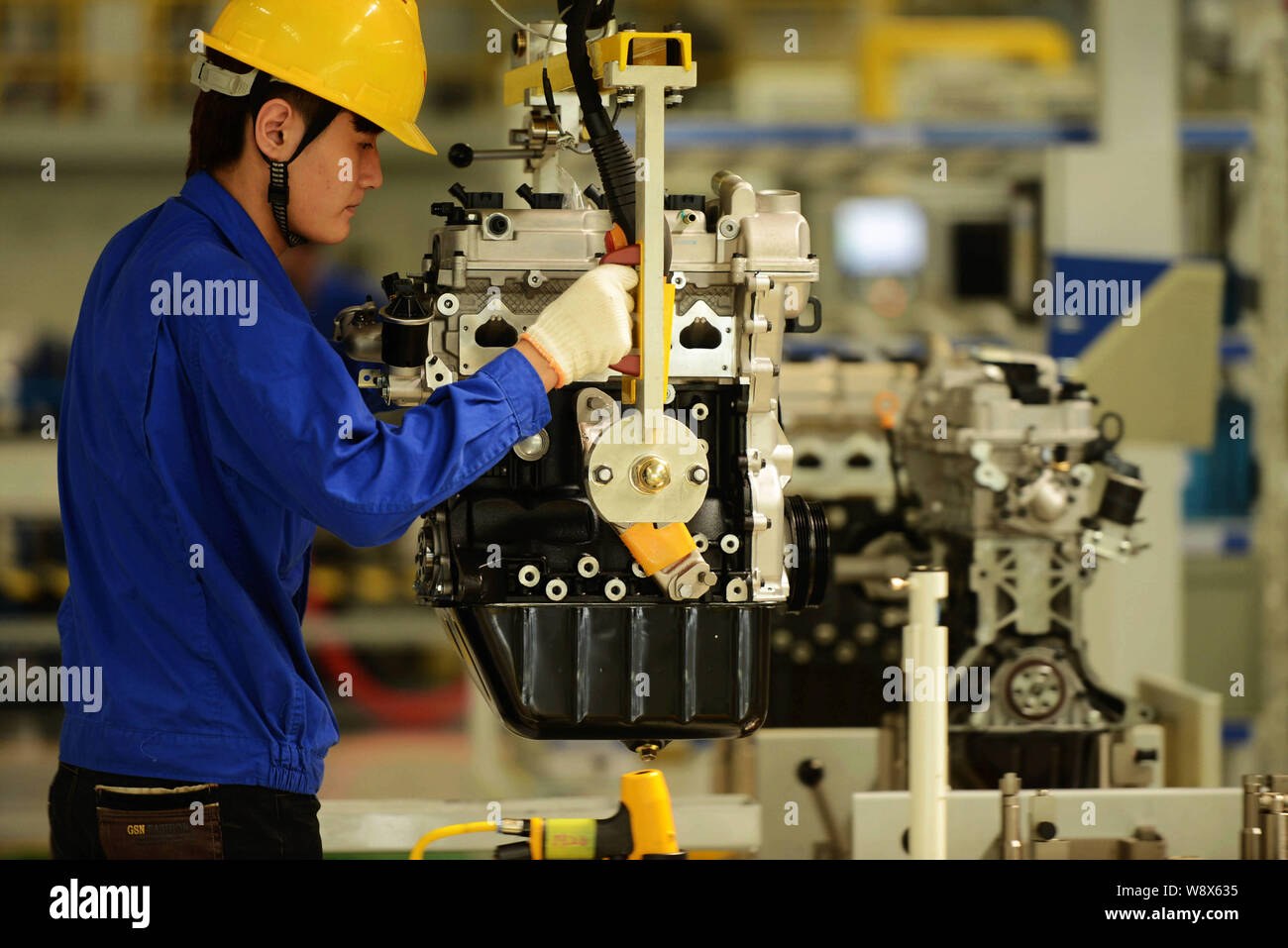 --FILE--A Chinese worker assembles a car engine on the assembly line at ...