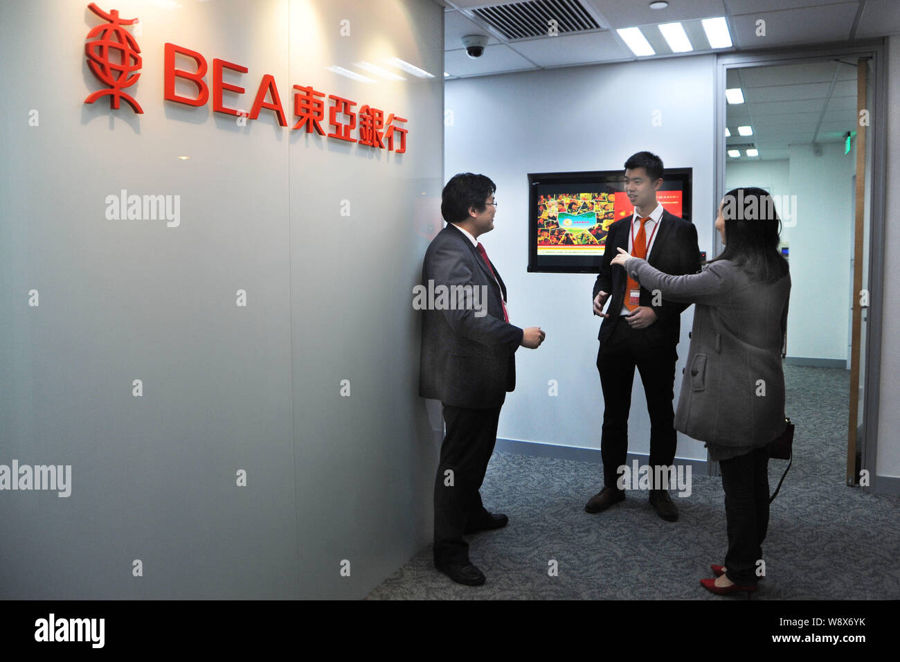 --FILE--Chinese employees talk at a branch of Bank of East Asia (BEA ...
