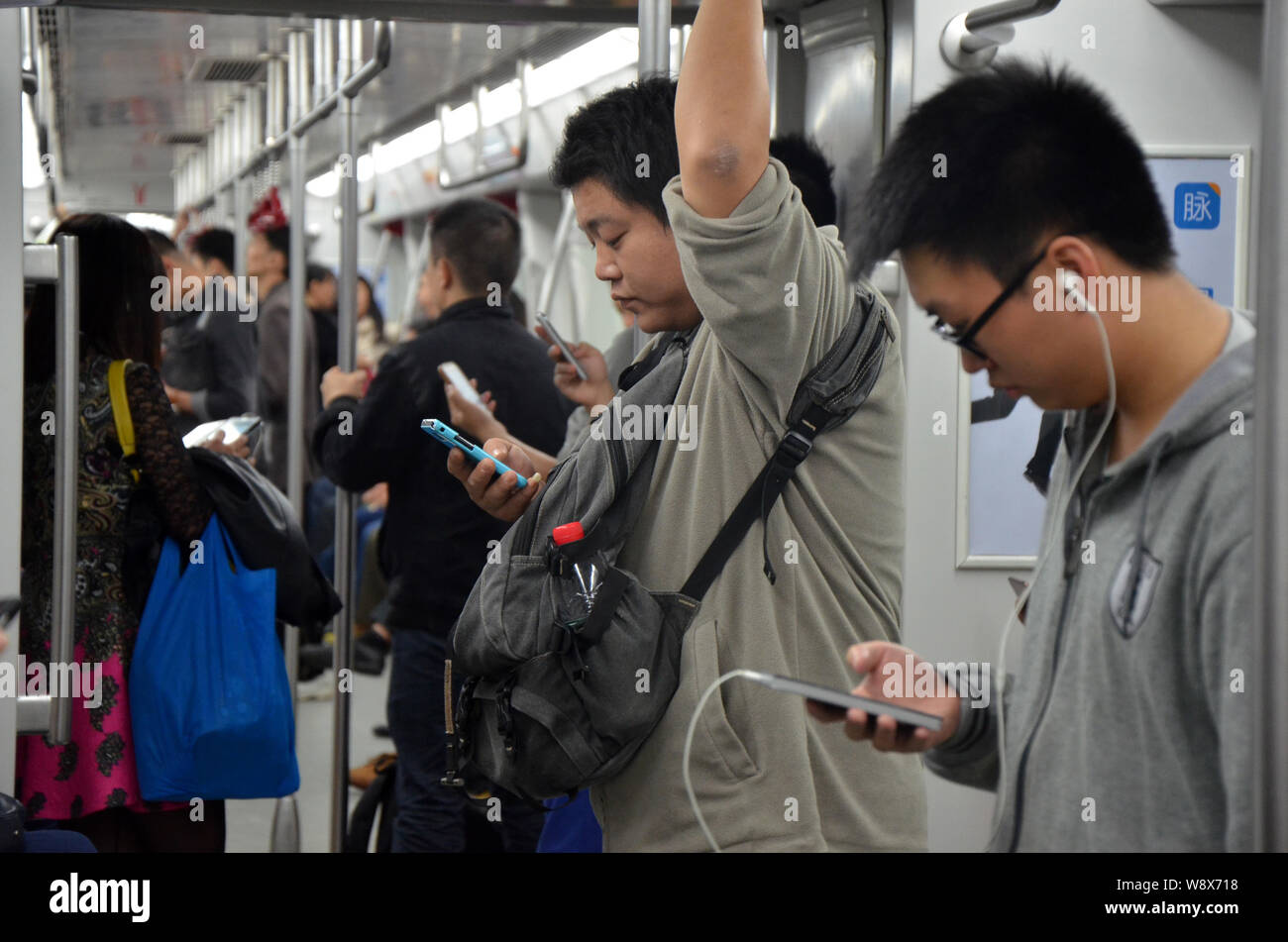 --FILE--Passengers use their smartphones to surf the Internet in a ...