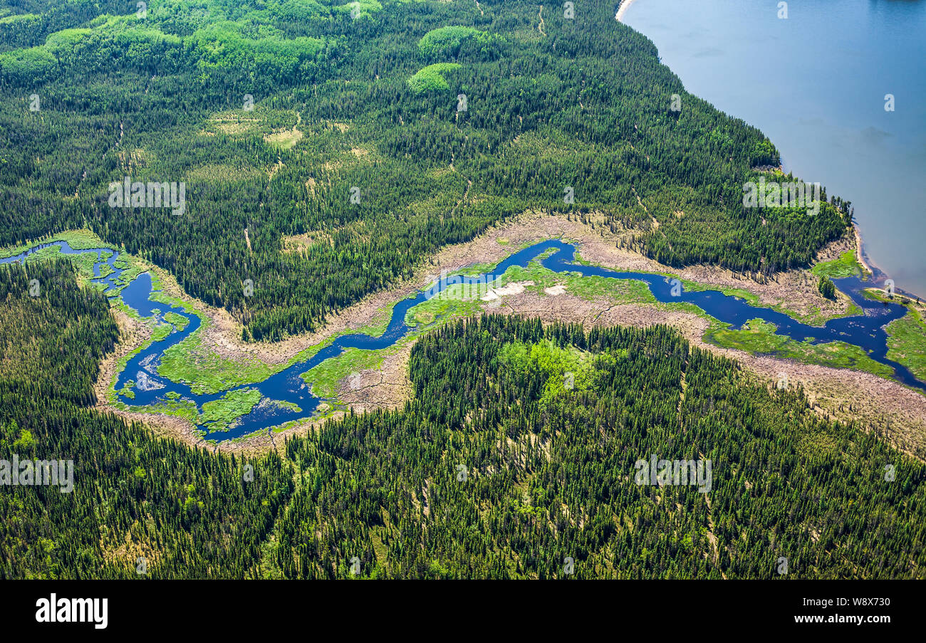 Aerial view of a stream entering a small lake in Alberta's boreal ...