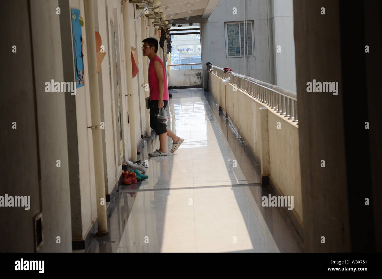 A student enters his dormitory room on a corridor cleaned by students ...