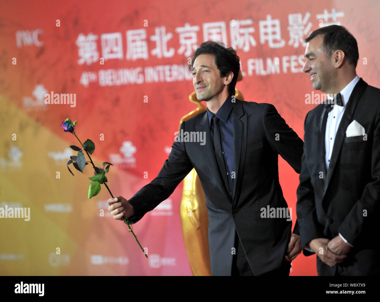 American actor Adrien Brody, left, holds a rose on the red carpet for ...