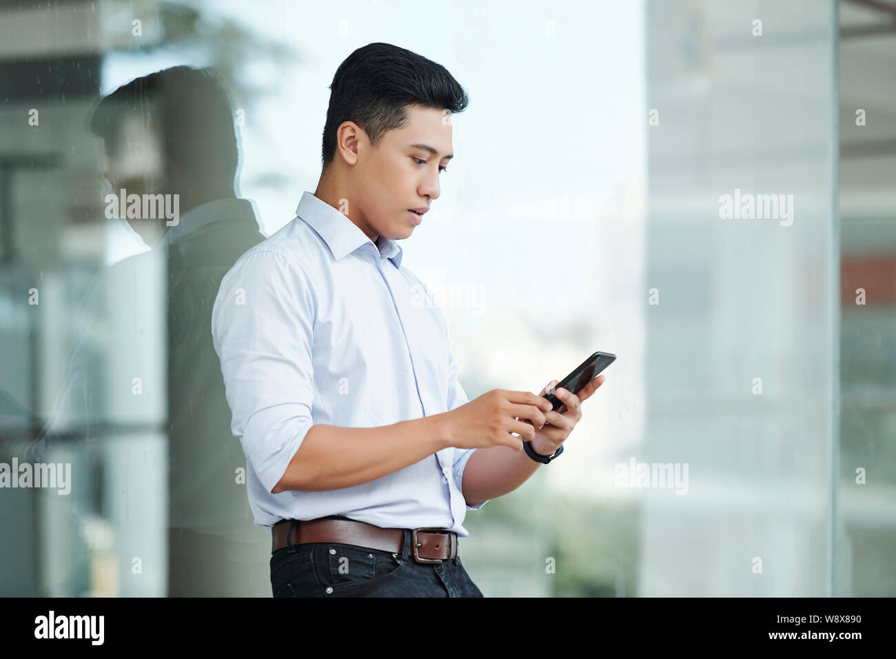 Young entrepreneur checking phone Stock Photo - Alamy