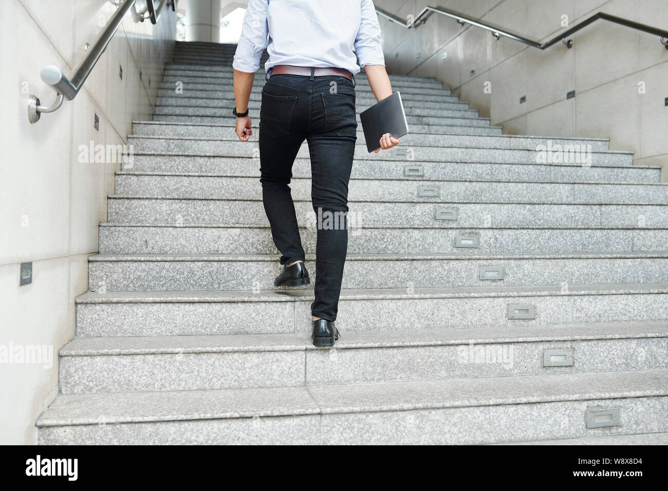 Businessman walking up steps hi-res stock photography and images - Alamy