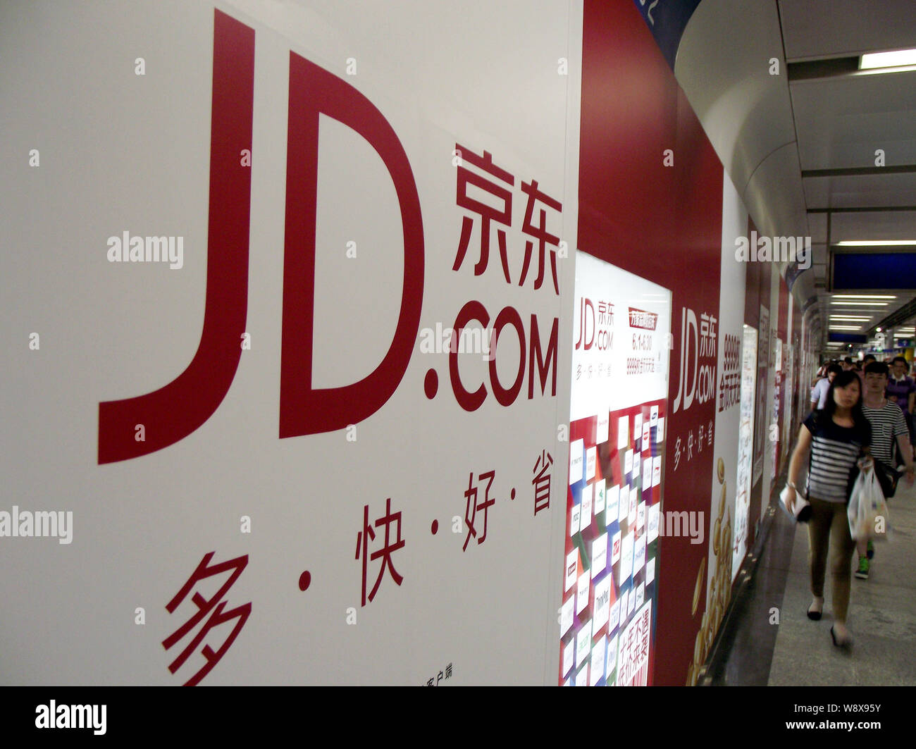 --FILE--Pedestrians walk past an advertisement for online shopping site ...