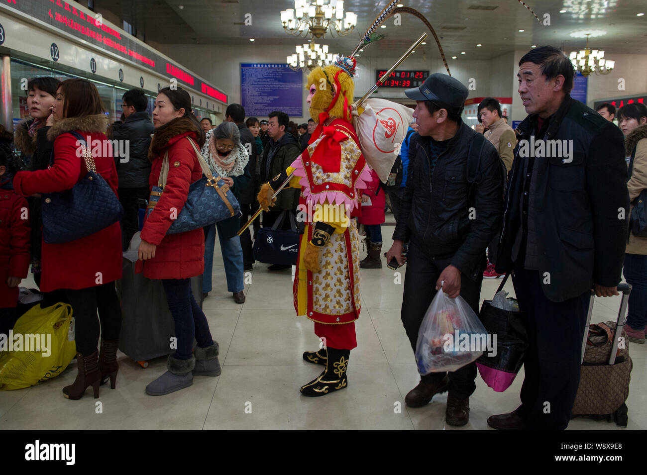 A Chinese young man, dressed as Monkey King, queue up to buy a train ...