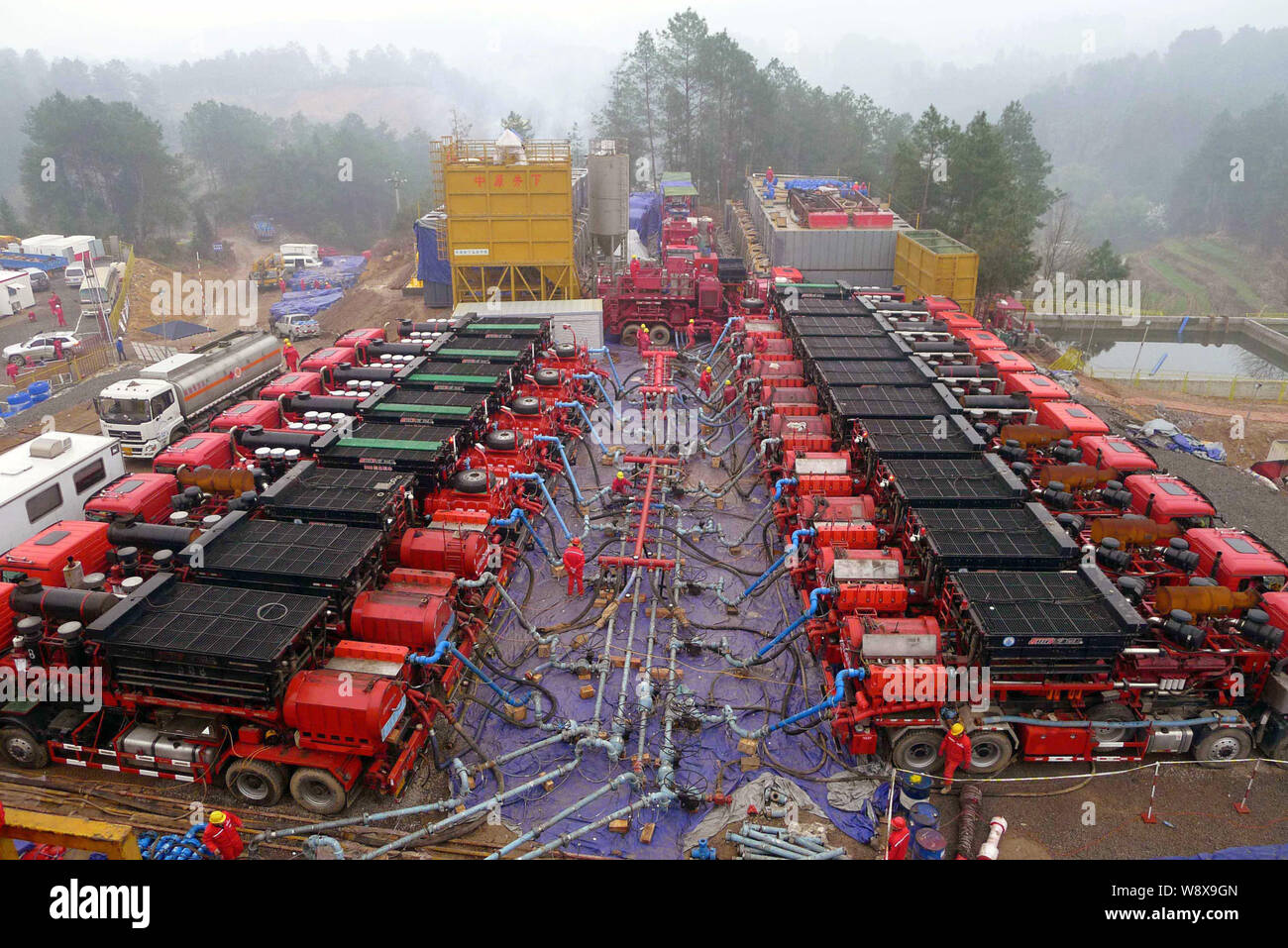 --FILE--Chinese workers monitor the pipes connected to vehicles during ...