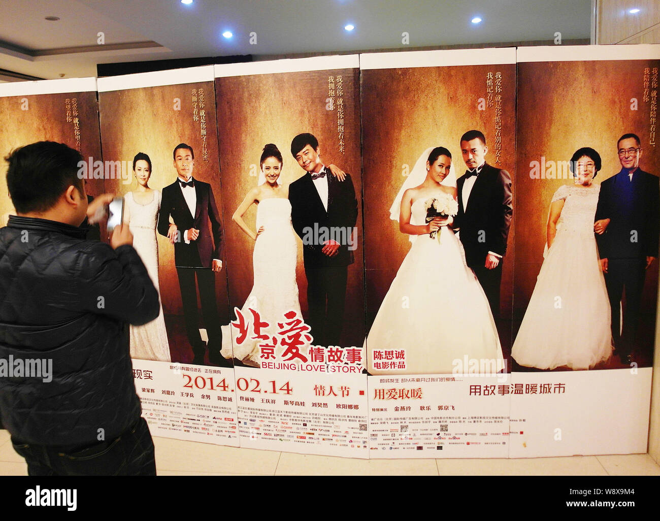 --FILE--A Chinese moviegoer takes photos of a poster for the movie ...