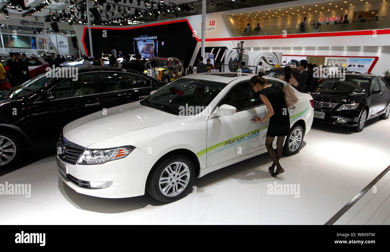 A visitor looks at a Trumpchi electric car of GAC Group during the 13th ...