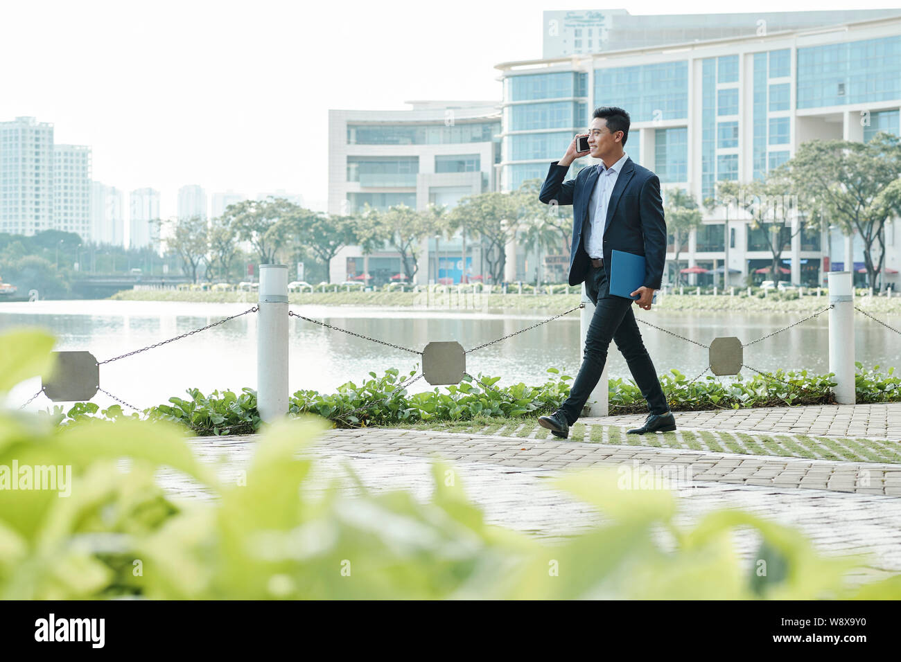 Asian office worker walking outdoors hi-res stock photography and ...