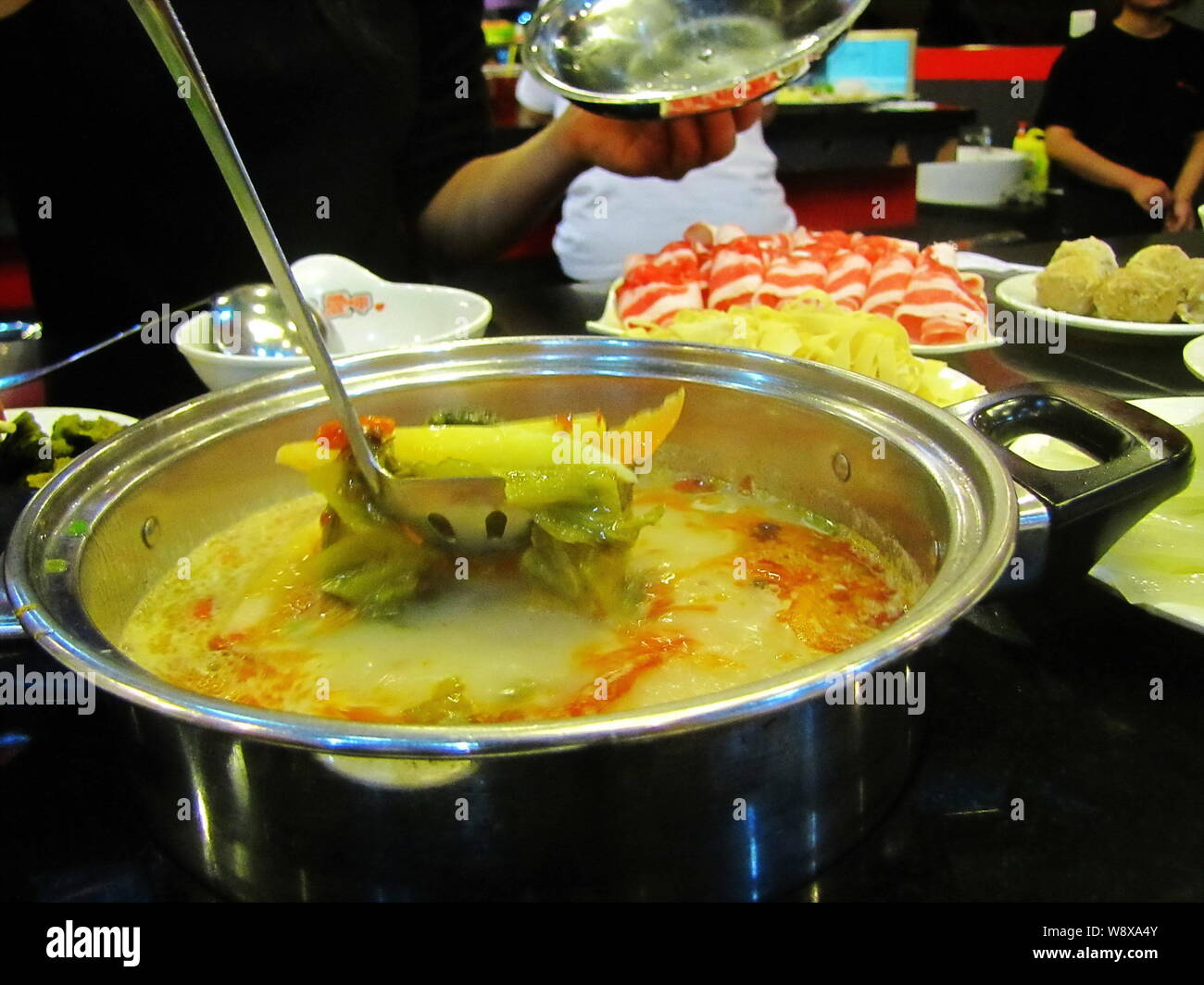 --FILE--A waiter serves hotpot at a hot-pot restaurant in Shanghai ...