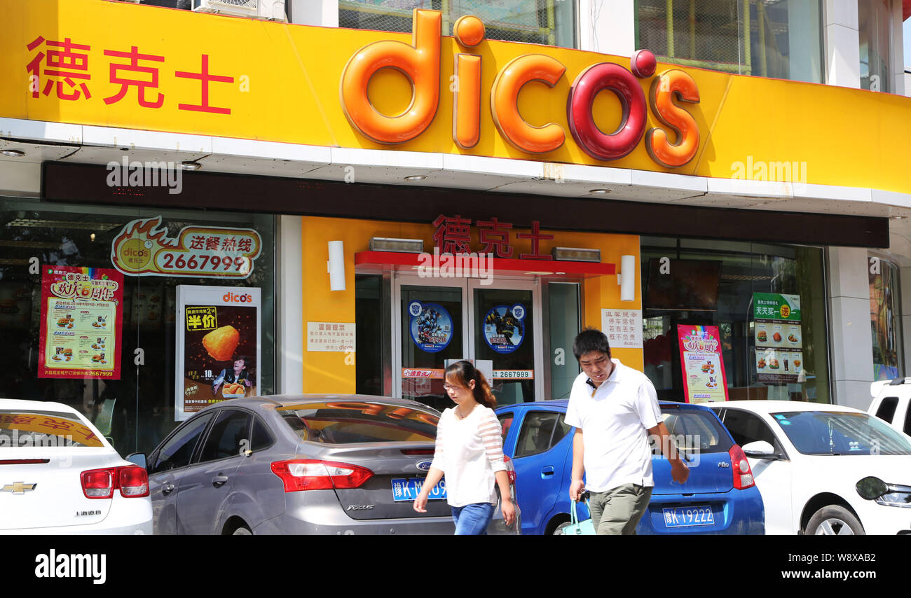 --FILE--Pedestrians walk past a Dicos fastfood restaurant in Xuchang ...