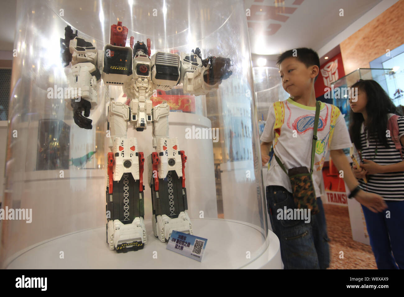 Visitors look at a Transformer toy during an exhibiton at the Joy City ...