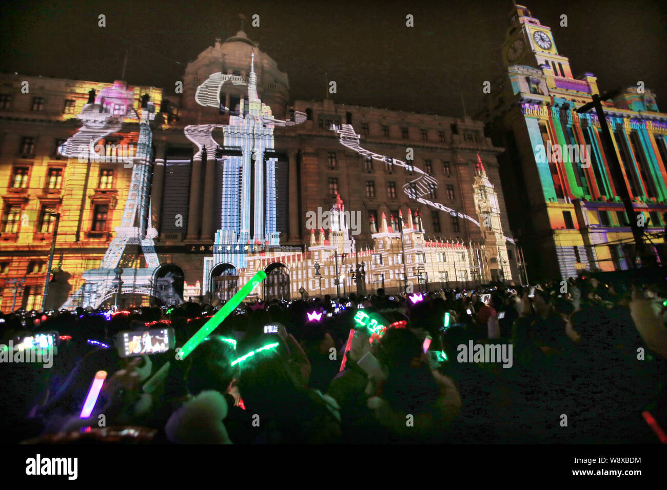 People watch a 4D light show on the Bund during a gala to celebrate the ...