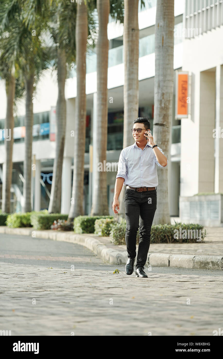 Positive man using mobile walking hi-res stock photography and images ...