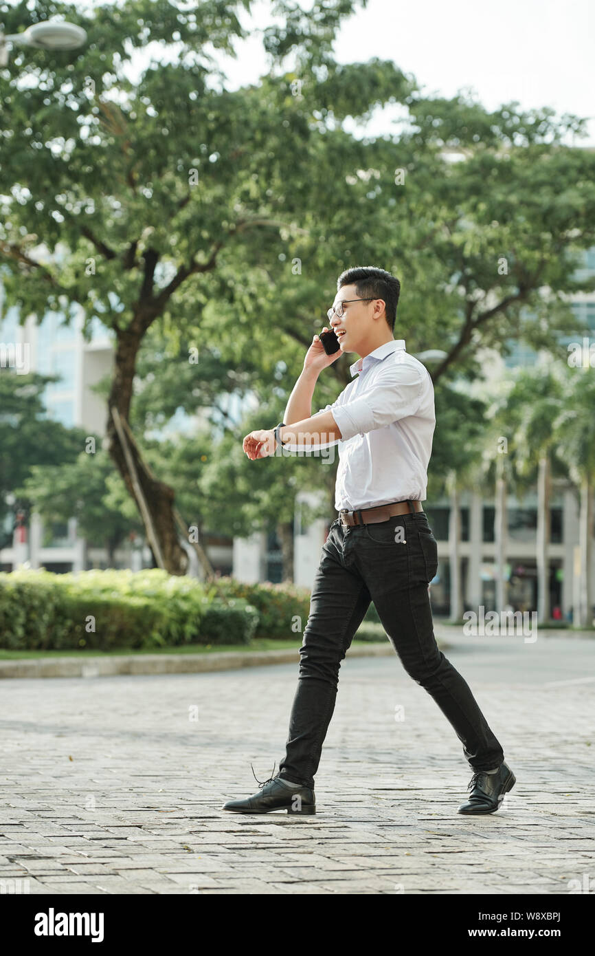 Walking man talking on phone Stock Photo - Alamy