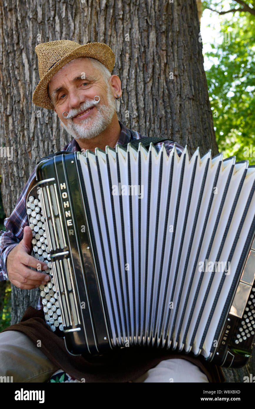Friendly musician playing accordion in the Park of 28 Panfilov ...