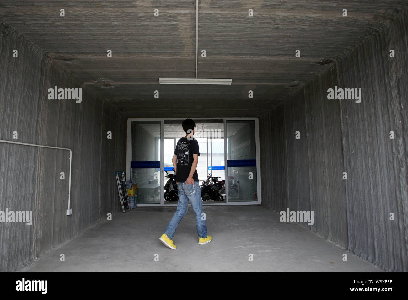 A man visits one of the ten 3D printed houses at the Qingpu Park of the ...
