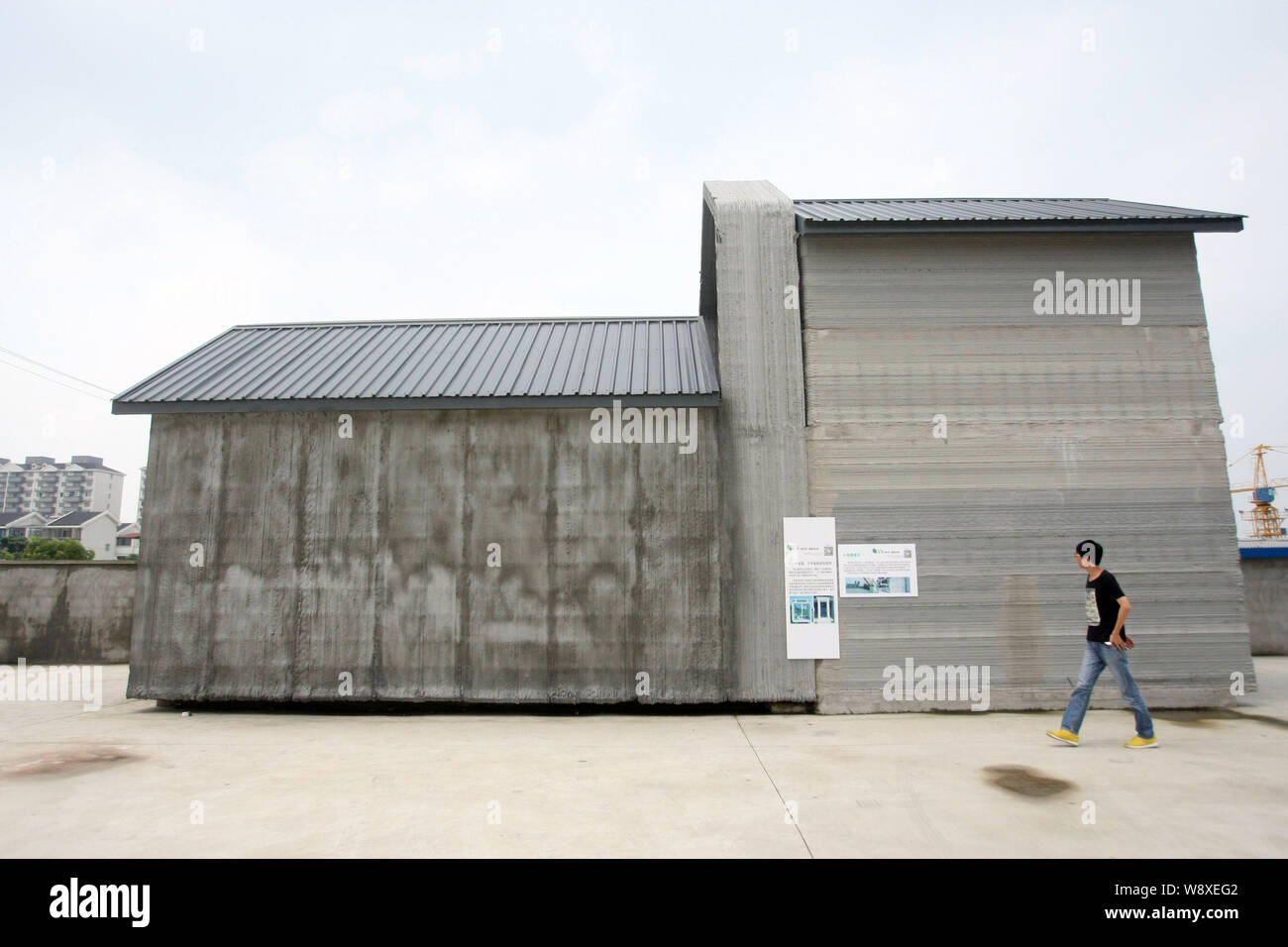A man walks past one of the ten 3D printed houses at the Qingpu Park of ...
