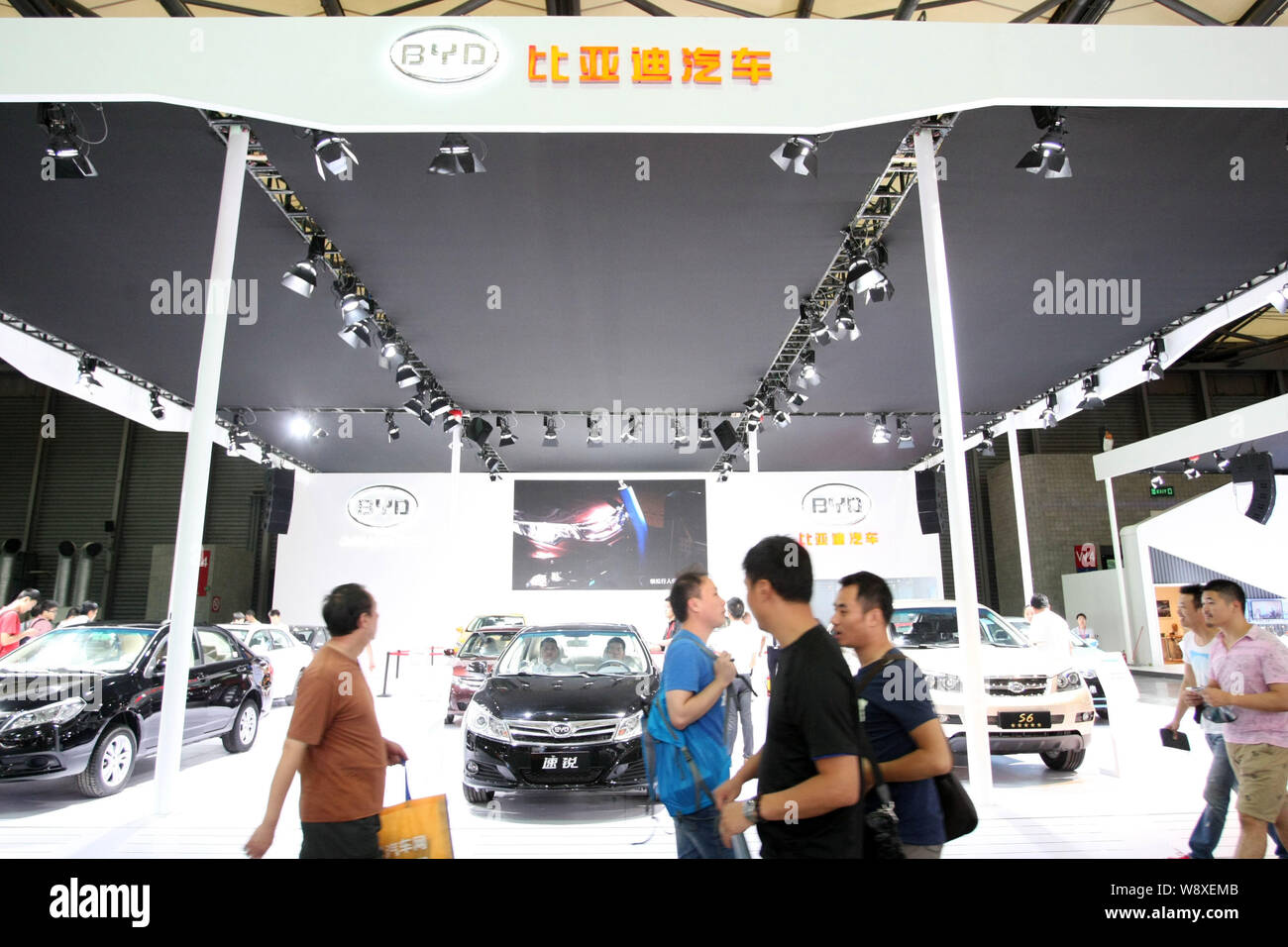 Visitors walk past the stand of BYD during the 2014 Pudong ...