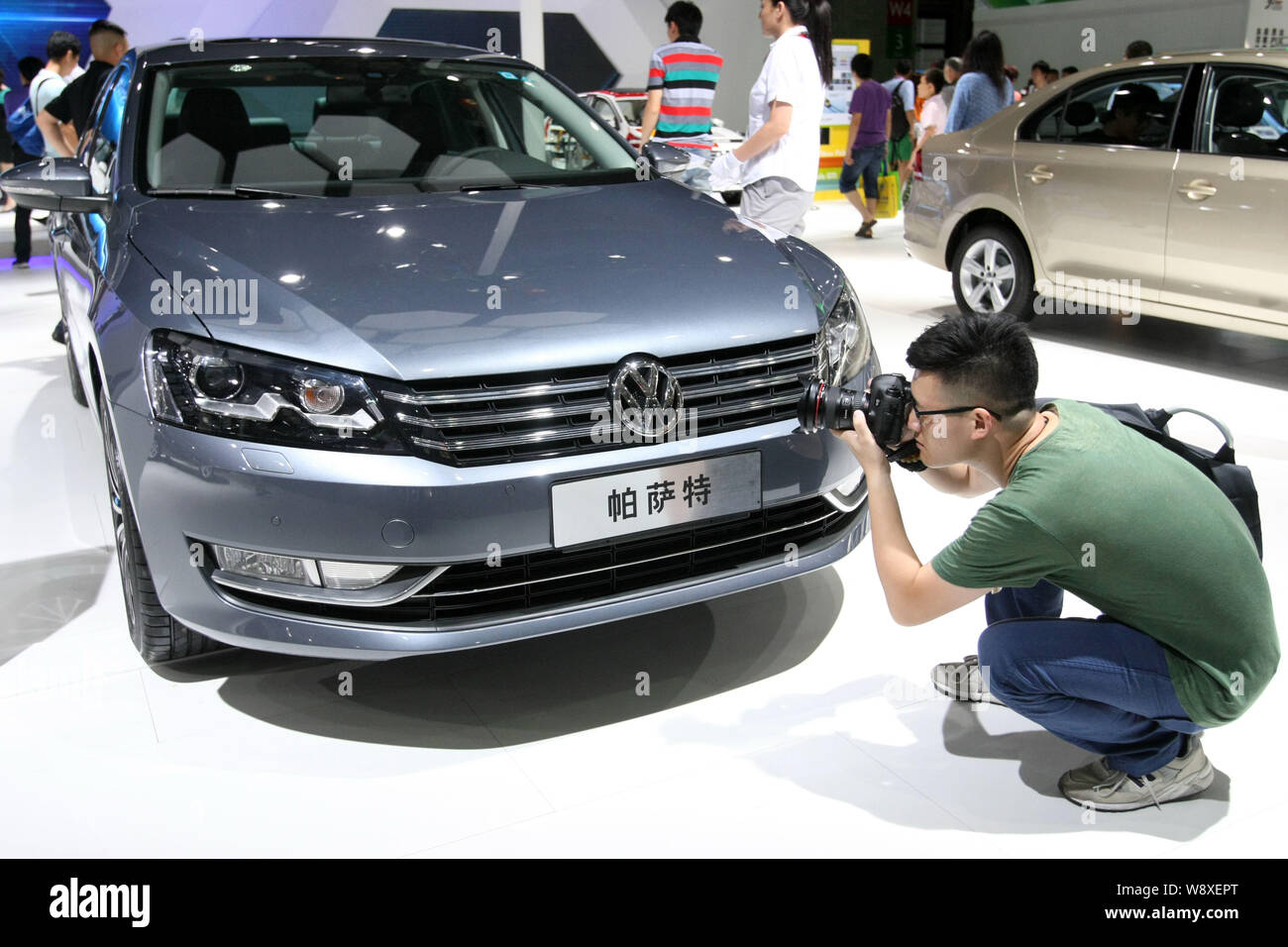 --FILE--A visitor takes photos of a Passat of Shanghai Volkswagen, a ...