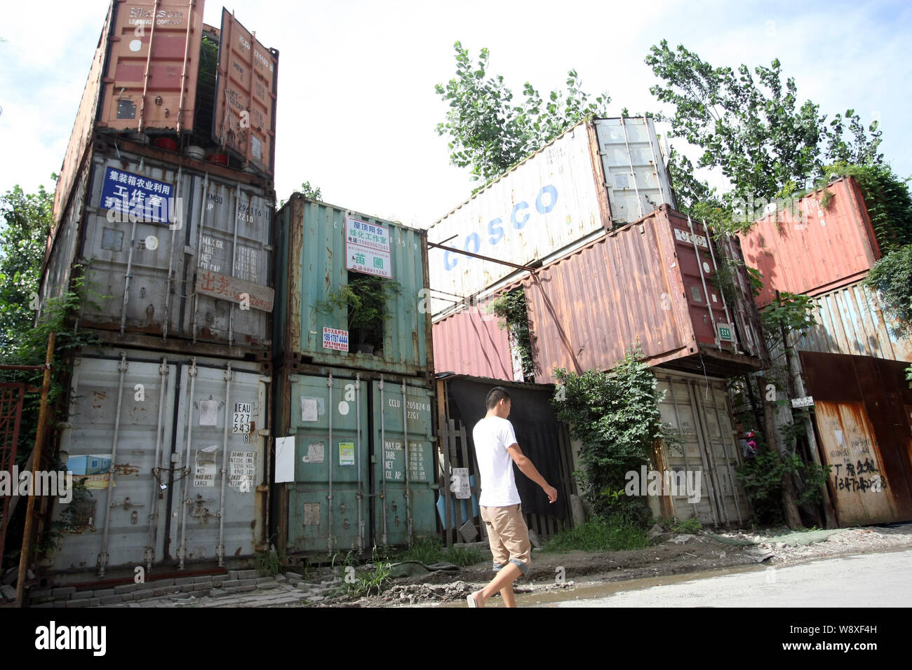 A pedestrian walks past a cluster of shipping-container homes in Pudong ...