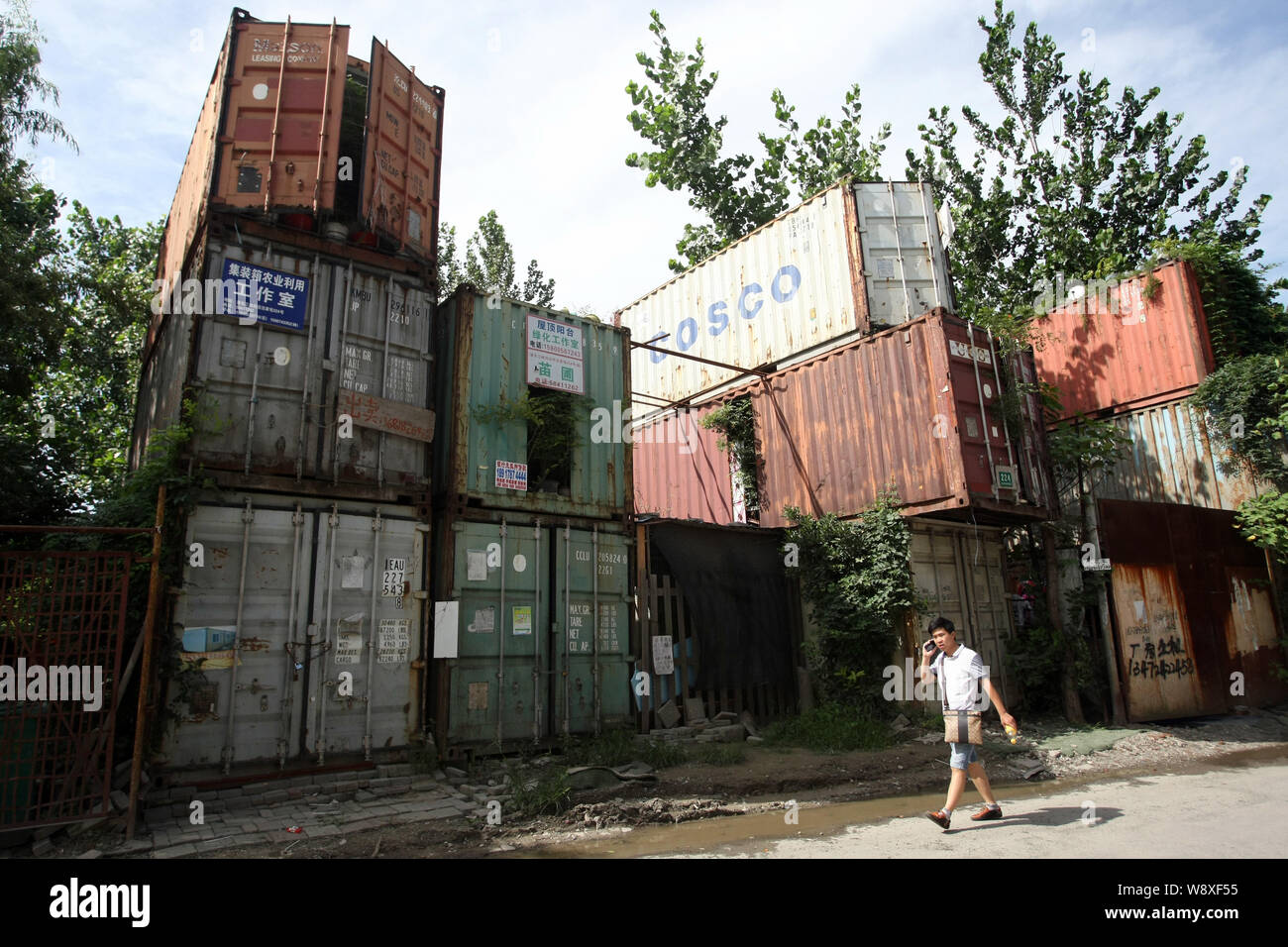 A pedestrian walks past a cluster of shipping-container homes in Pudong ...