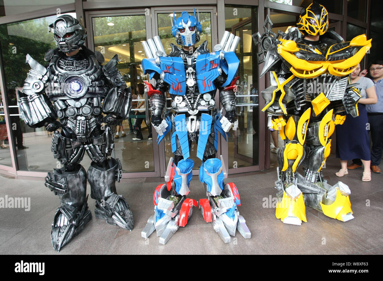 Three performers dressed in their Transformers costumes pose at the ...