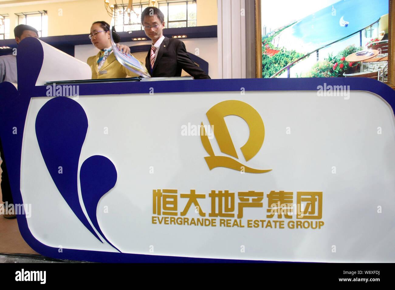 --FILE--Chinese employees are seen at the stand of Evergrande Real ...