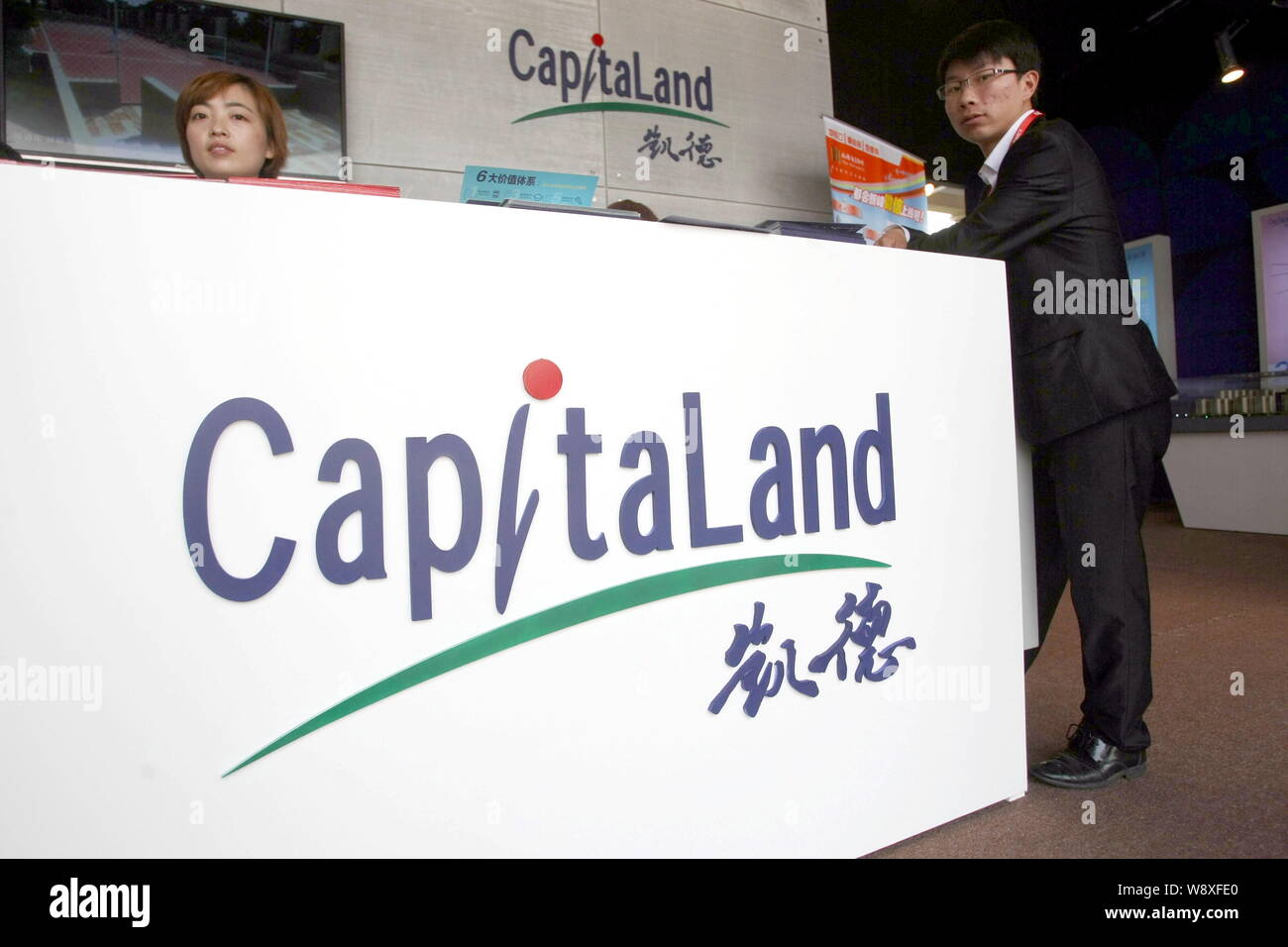 --FILE--Chinese employees work at the stand of CapitaLand during a real ...