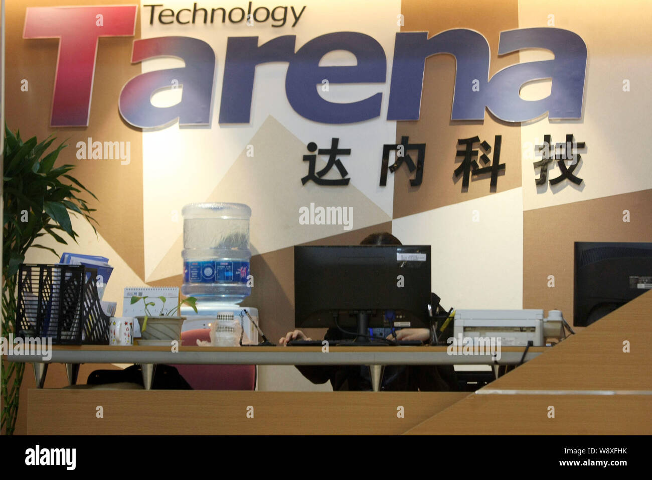 A Chinese employee works at the front desk of the Shanghai office of IT ...