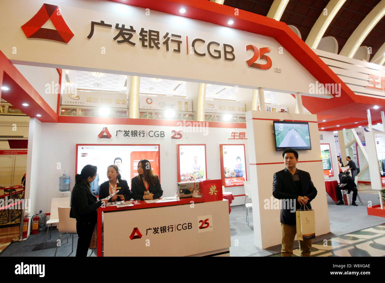 --FILE--A visitor talks with employees at the stand of China Guangfa ...