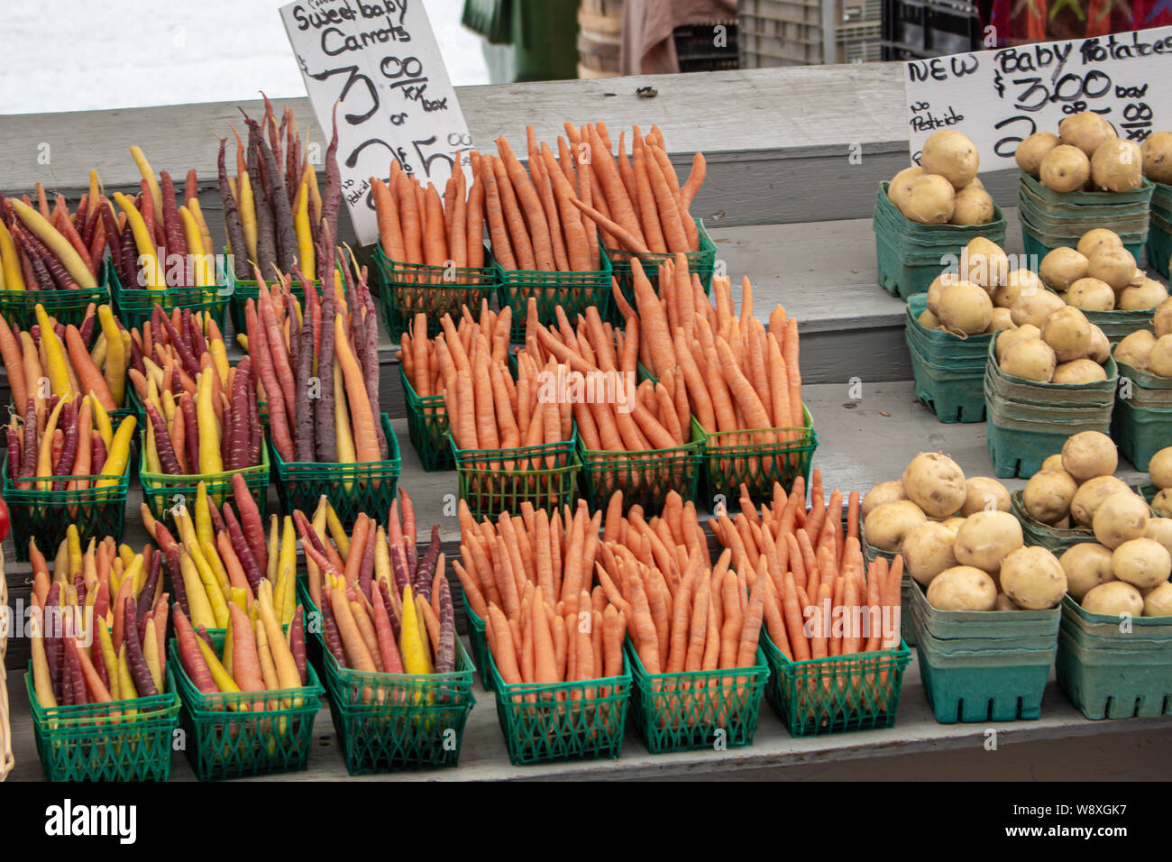 A street vendor's stall offers carrots and potatoes in its farmer's ...