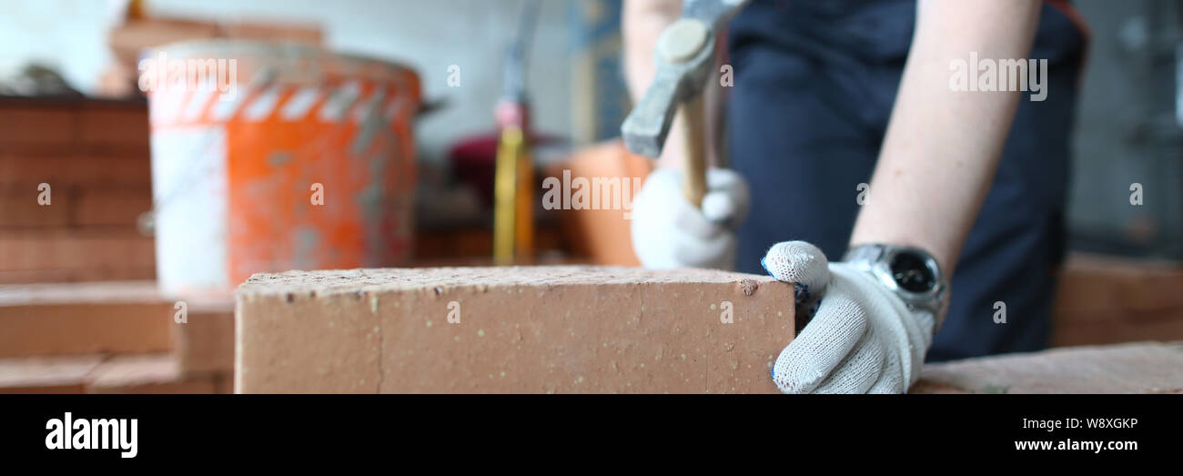 Skilled bricklayer putting red block Stock Photo - Alamy