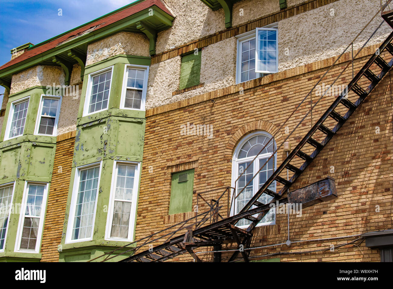 The brightly-lit wall of a small apartment building features vibrant ...