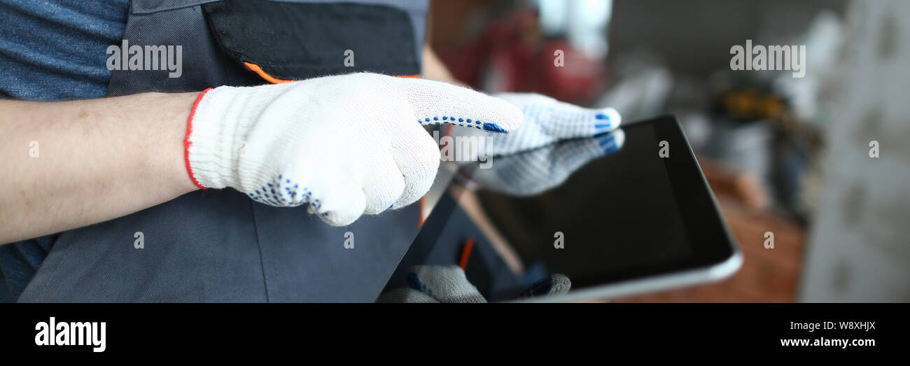 Builder holding modern tablet Stock Photo - Alamy