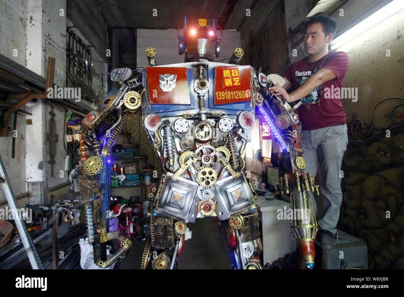 Liu Bo, a Chinese repairman, adjusts a Transformer robot made from ...