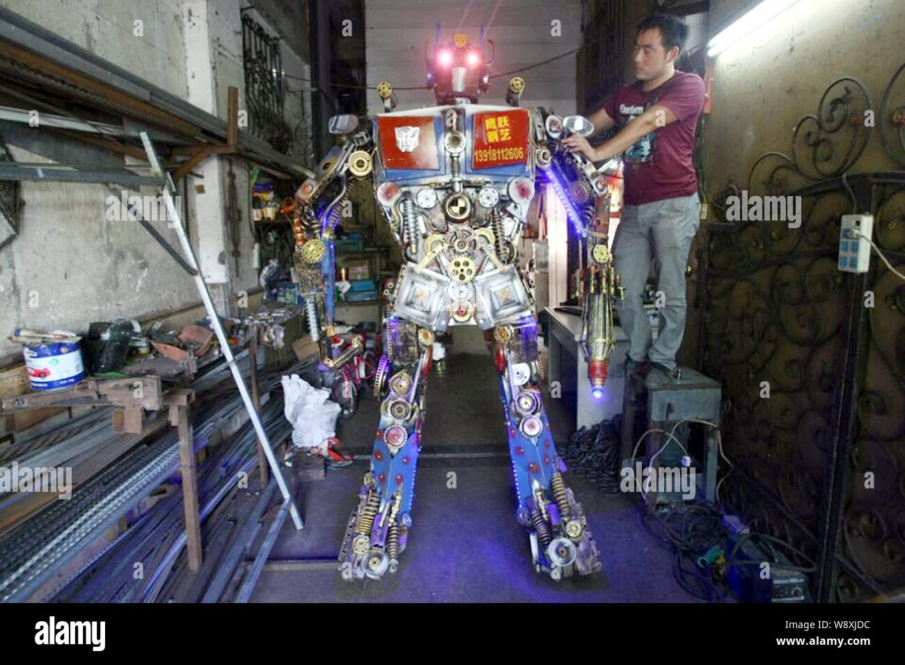 Liu Bo, a Chinese repairman, adjusts a Transformer robot made from ...