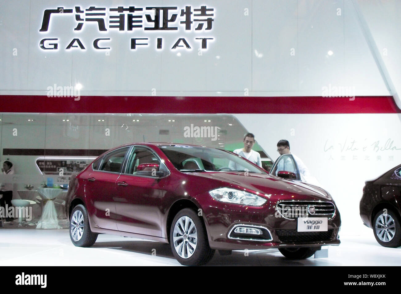 --FILE--Visitors look at a Fiat Viaggio at the stand of GAC Fiat ...