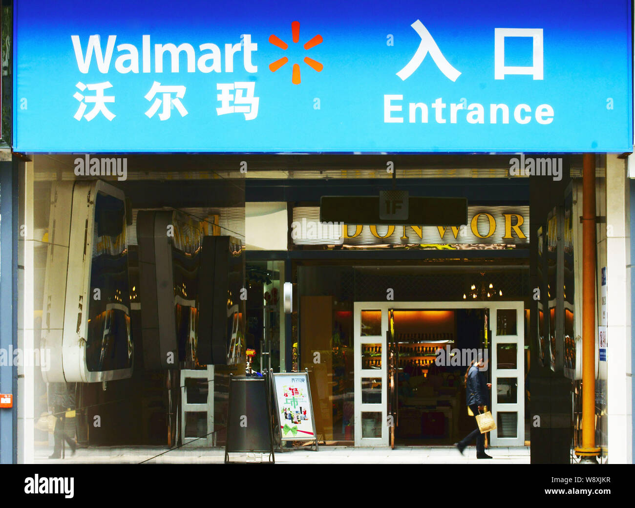 --FILE--A pedestrian walks past the entrance of a Walmart supermarket ...